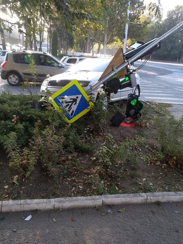 Un semafor si un indicator rutier, doborate la pamant de un sofer care ...